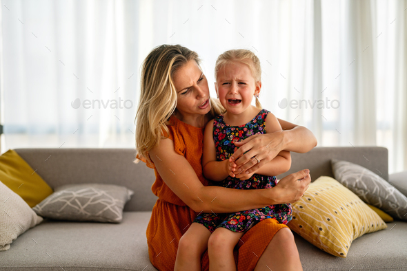 Mother comforting her crying child after she hit her hand Stock Photo ...