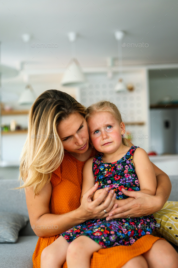 Mother comforting her crying child after she hit her hand Stock Photo ...