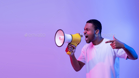 Full length portrait of aggressive young man shouting using megaphone ...