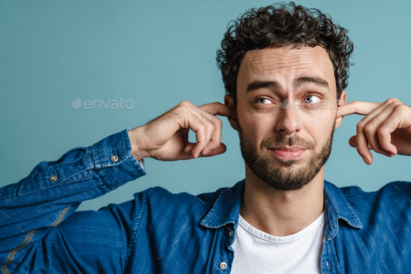 Caucasian handsome guy posing and plugging his ears Stock Photo by ...