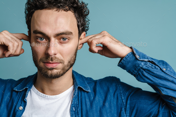 Caucasian handsome guy posing and plugging his ears Stock Photo by ...