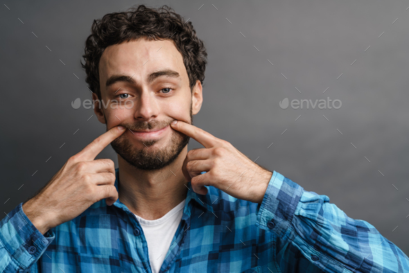Caucasian handsome guy making smile on his face with fingers Stock ...
