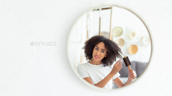 Disgruntled millennial african american woman feel pain doing hairstyle ...