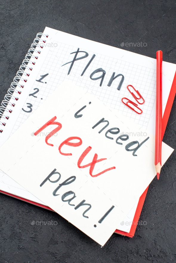 top view office stuffs i need new plan and plan written on notepads red ...