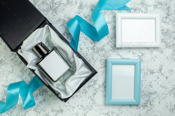 top view perfume bottle in perfume box empty picture frames on grey ...