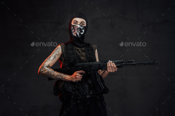 Female soldier poses in dark background holding assault rifle Stock ...