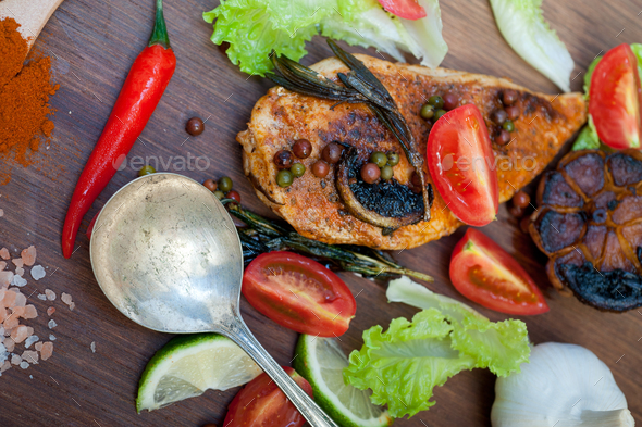 wood fired hoven cooked chicken breast on wood board Stock Photo by keko64