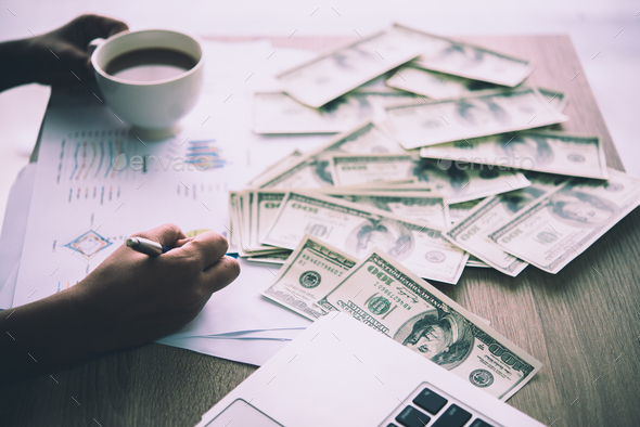 Working place of trader. The table covered by cash notes, keyboard and ...