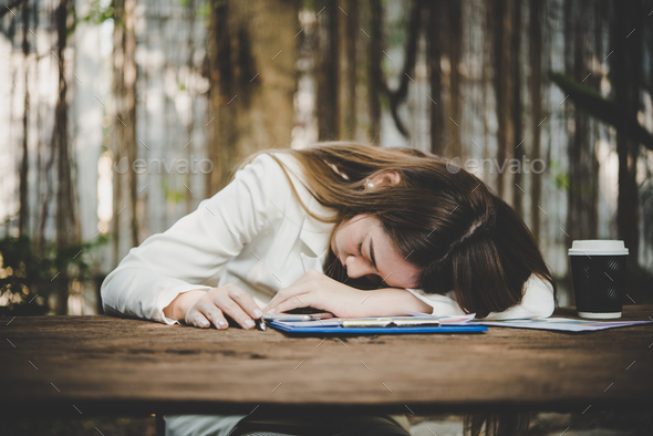 Tired and exhausted freelance woman sleeping on laptop computer in ...