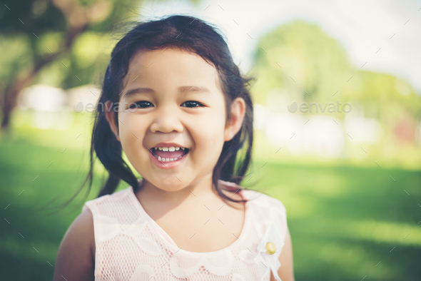Portrait of little girl smiling showing happy in the park Stock Photo ...