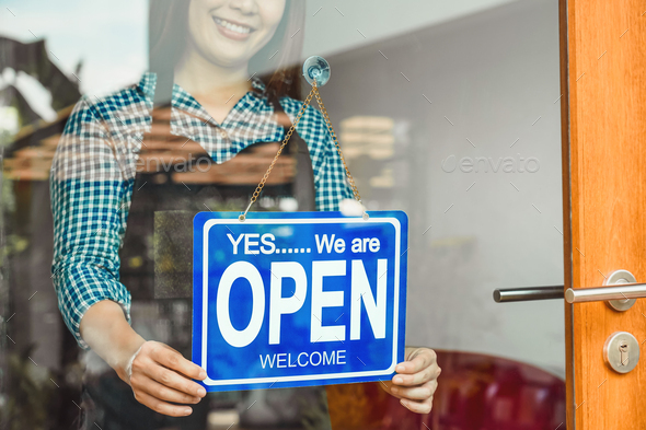 Closeup hand of Asian young woman setting open sign at the shop glasses ...