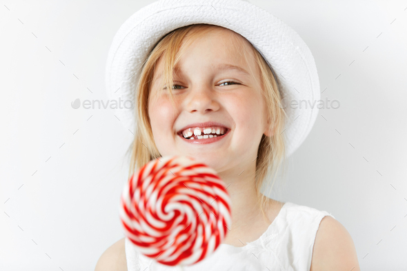 Cheerful and delighted little Caucasian girl laughing with squinty eyes ...