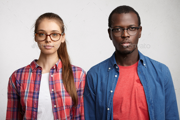 Horizontal portrait of two mixed race people posing against white ...