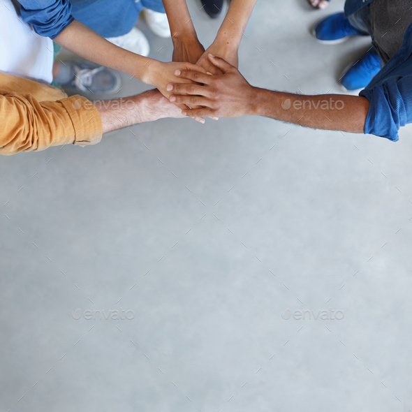 Horizontal portrait of group of people standing together stacking their ...