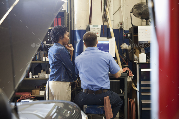 Mechanic and customer look at computer screen in auto repair shop Stock ...
