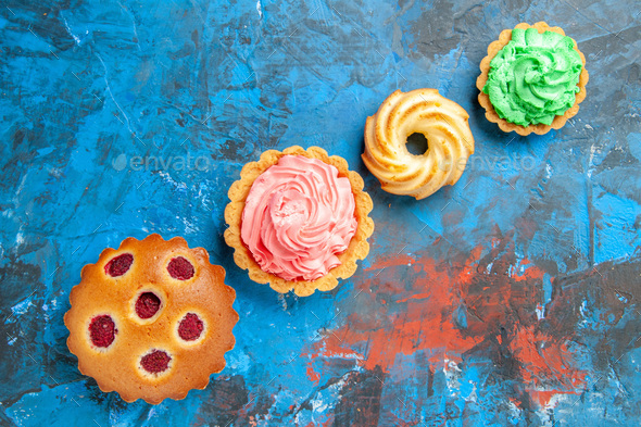 top view diagonal row raspberry cake small tarts biscuit on blue table ...