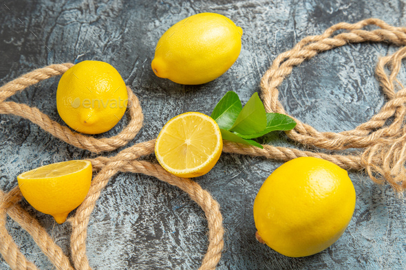 front view fresh lemons with ropes on light-dark background citrus ...