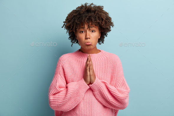 Begging African American woman has pity expression on face, keeps hands ...
