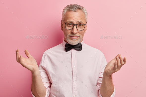 Photo of questionable man with thick beard, grey hair, spreads hands ...