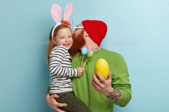 Happy father and daughter wears bunny ears, holds painted eggs ...