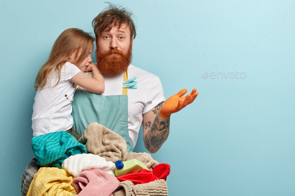 Busy overloaded father looks after little daughter and does household ...