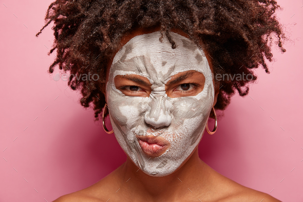 Home skin care concept. Attractive black lady purses lips, has ...
