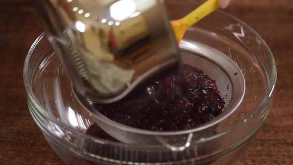 Woman Strains Berries Through a Sieve To Make Puree., Stock Footage