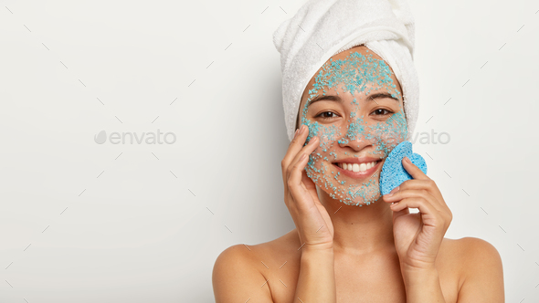 Cropped shot of happy positive woman with toothy smile, applies sea ...