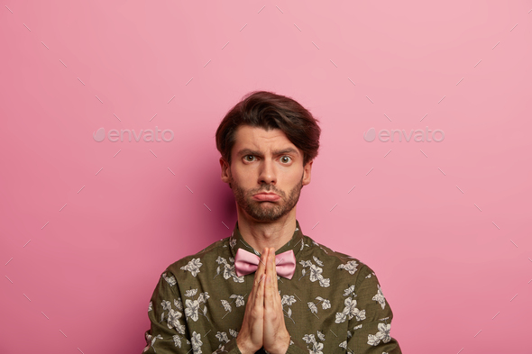 Pleading sad unshaven man has frustrated face expression, keeps palms ...