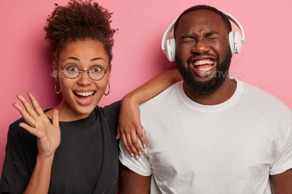 Horizontal shot of cheerful Afro girl leans at shoulder of boyfriend ...