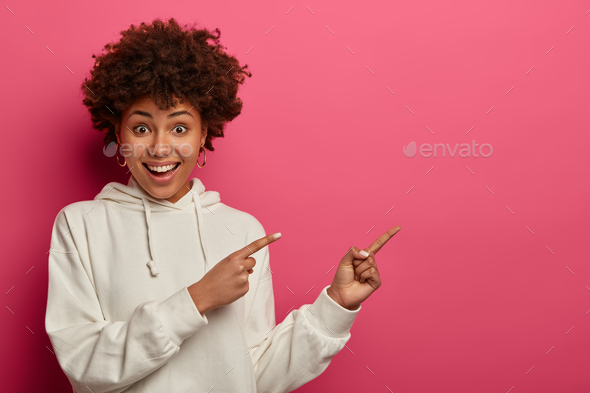 Horizontal view of glad young woman with cheerful expression shows ...