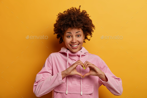 Body language and affection concept. Lovely caring woman shapes heart ...