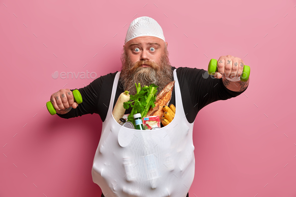 Fat motivated man goes in for sport, poses with high calorie food ...