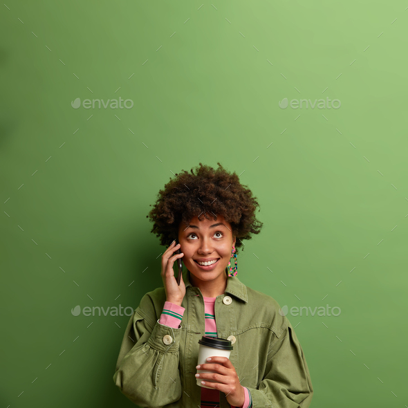 Happy ethnic female worker works productively with energetic coffee ...