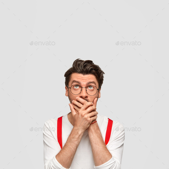 Indoor view of frightened shocked man tries to keeps silence, looks ...