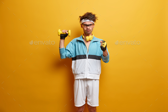 Serious strict male coach conducts fitness training, clenches fist ...