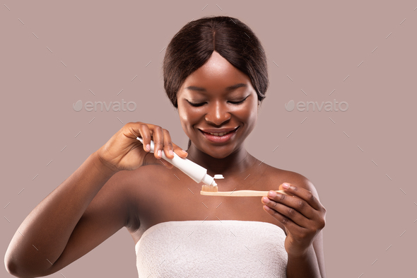 Daily Dental Care. Smiling Black Woman Pouring Toothpaste On Toothbrush ...
