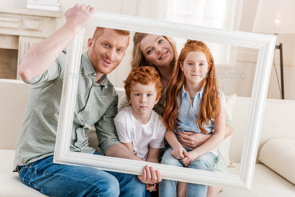 happy redhead family looking through white frame together, big family ...