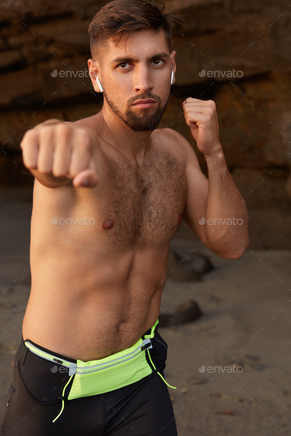 People, strength and power concept. Confident sportsman raises clenched ...