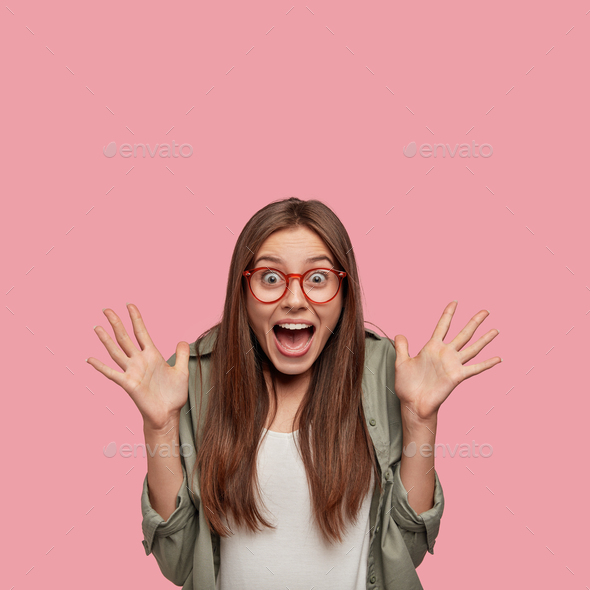 Impressed beautiful brunette young Caucasian woman stares with popped ...