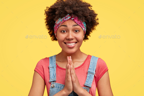 Portrait of beautiful dark skinned female with crisp hair, has pleading ...