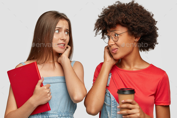 Horizontal shot of neurotic women look anxiously at each other, feel ...