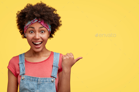 Horizontal shot of joyful curly dark skinned African American female ...