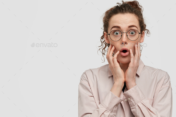 Photo of surprised European female gasps and gasps breath in shock ...