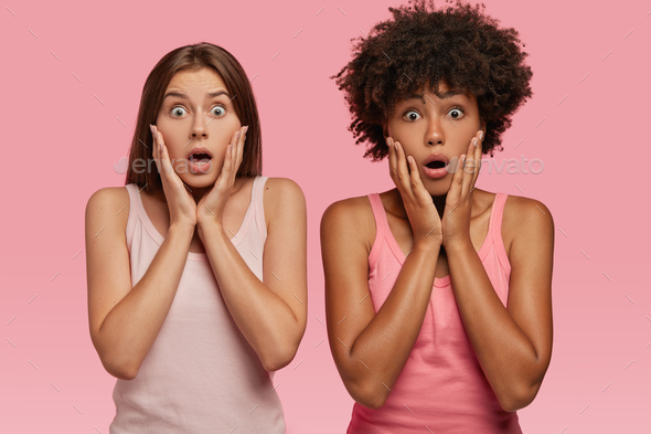 Indoor shot of worried intense surprised young girls stare anxious and ...