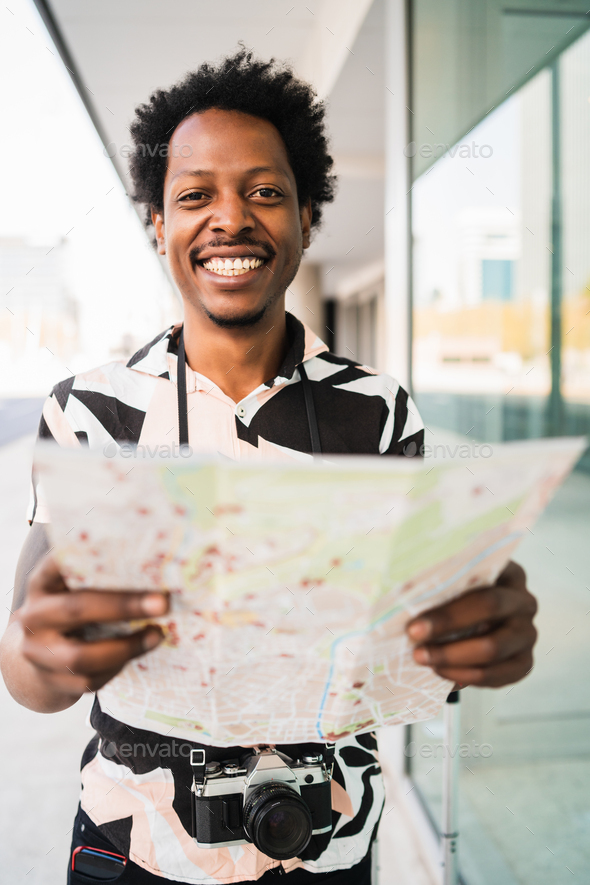 Tourist man looking for directions on map. Stock Photo by megostudio