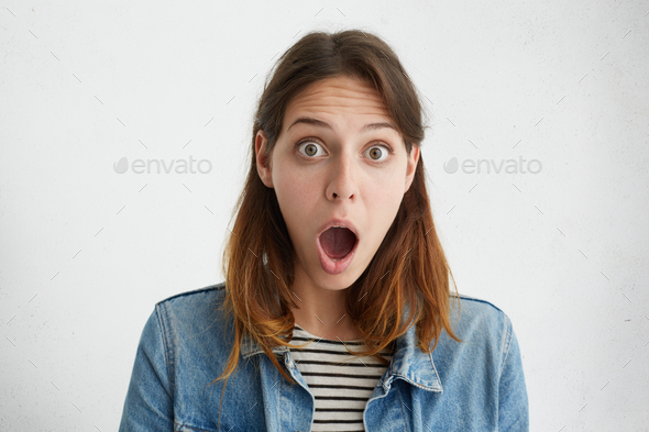 Cute female model looking with bugged eyes and widely opened mouth at ...