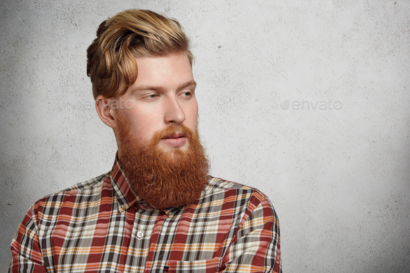 Portrait of young Caucasian brutal man with fuzzy beard wearing red ...