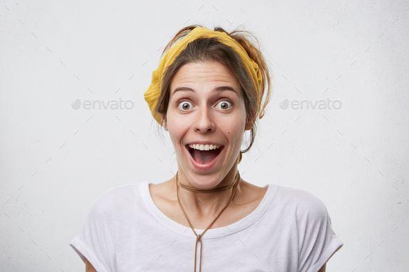 Excited female looking with widely opened eyes and jaw dropped having ...