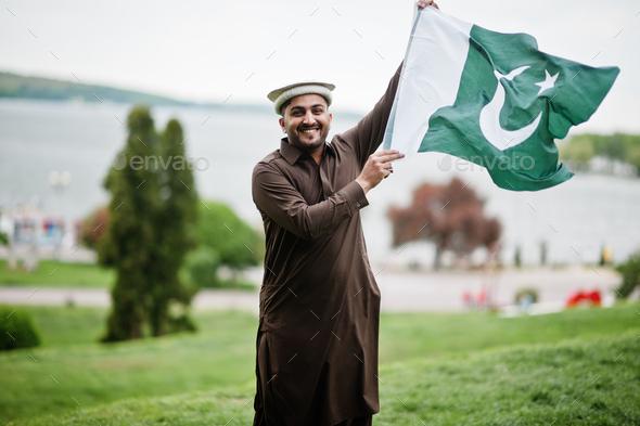Pakistani pathan man wear traditional clothes hold Pakistan flag. Stock ...